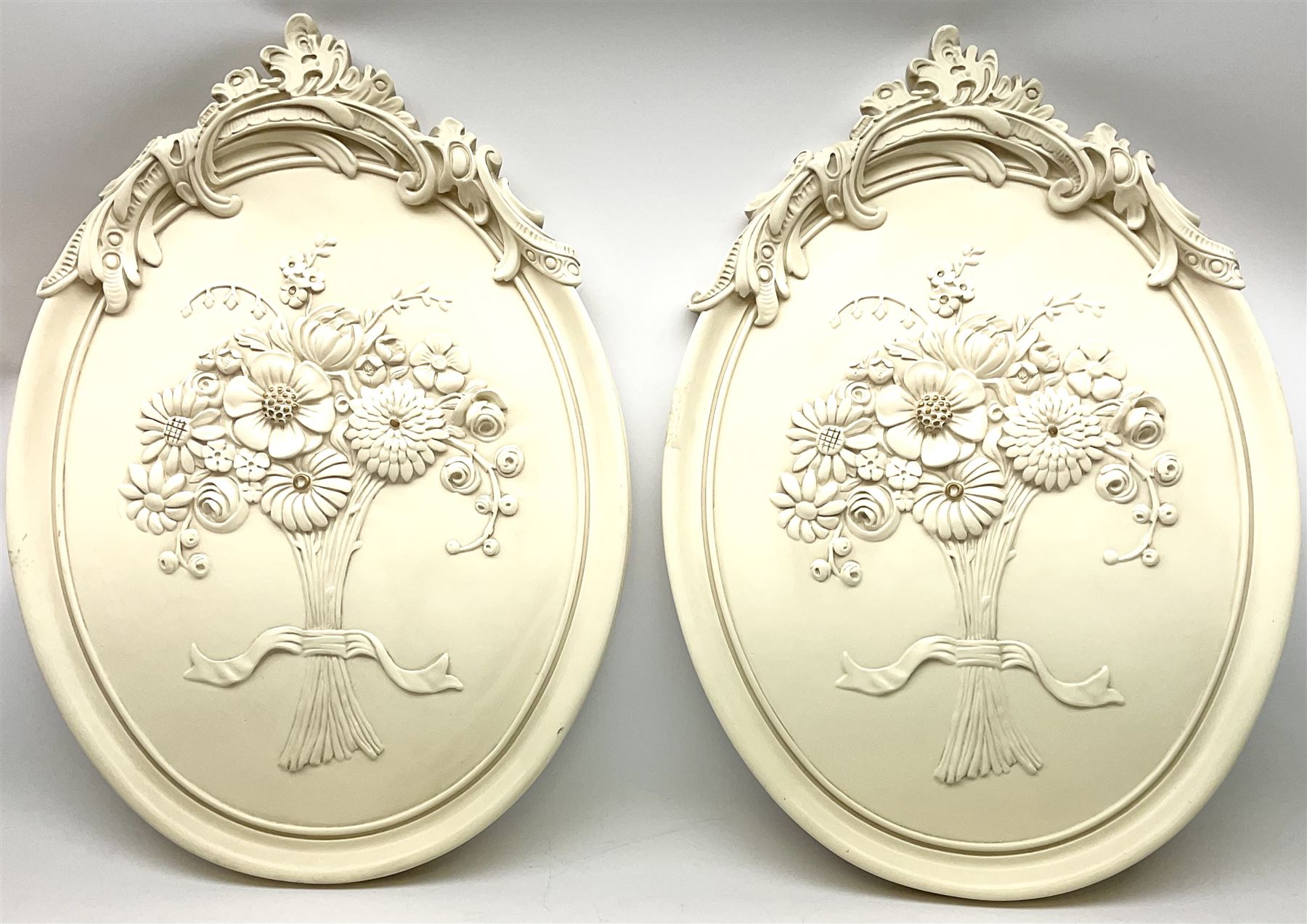Pair of ceramic wall plaques each decorated in relief with scroll ...