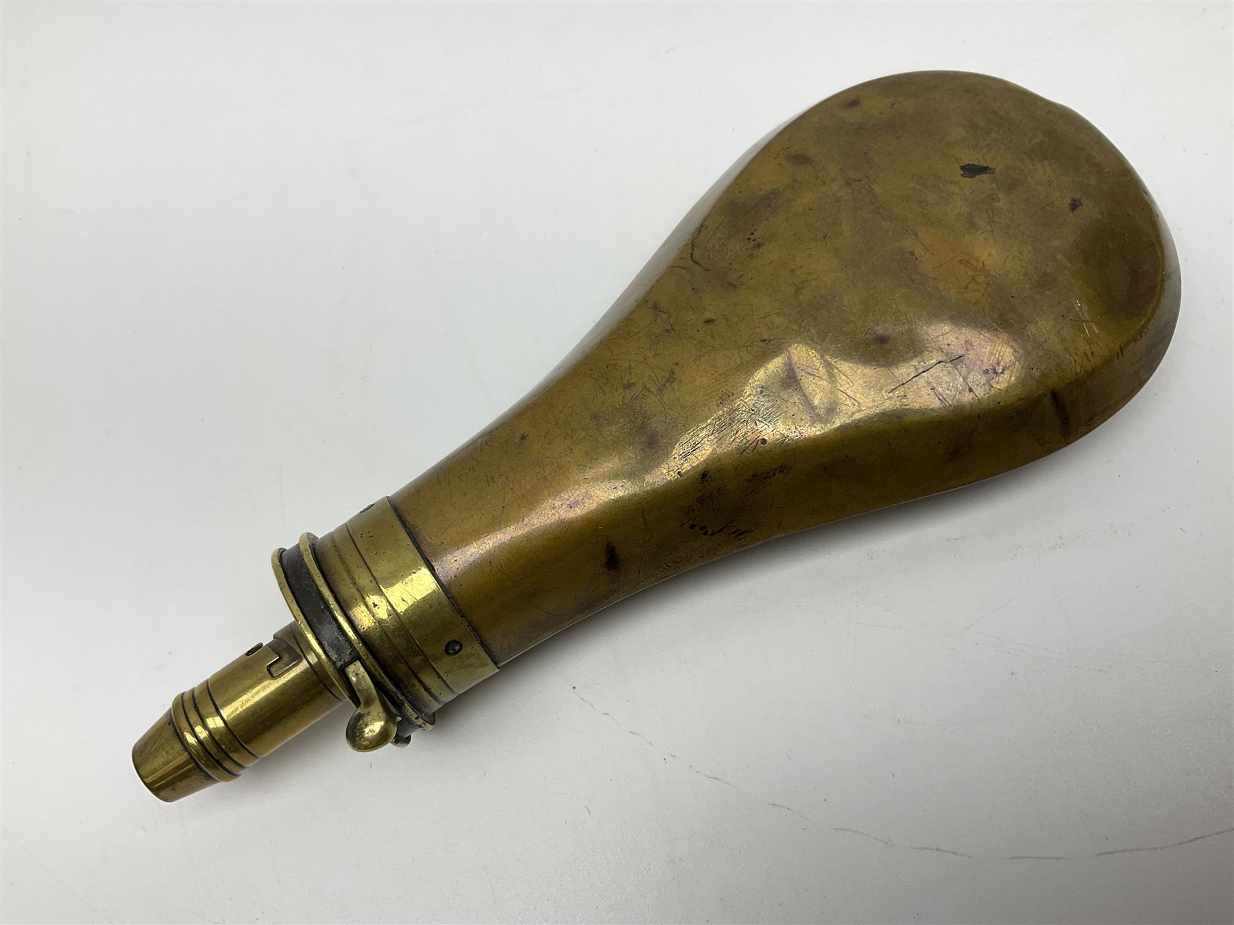 Two brass mounted leather shot flasks with thumb action nozzles; Dixon ...