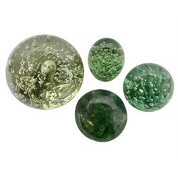 Four Victorian and later green glass dump paperweights with with air ...