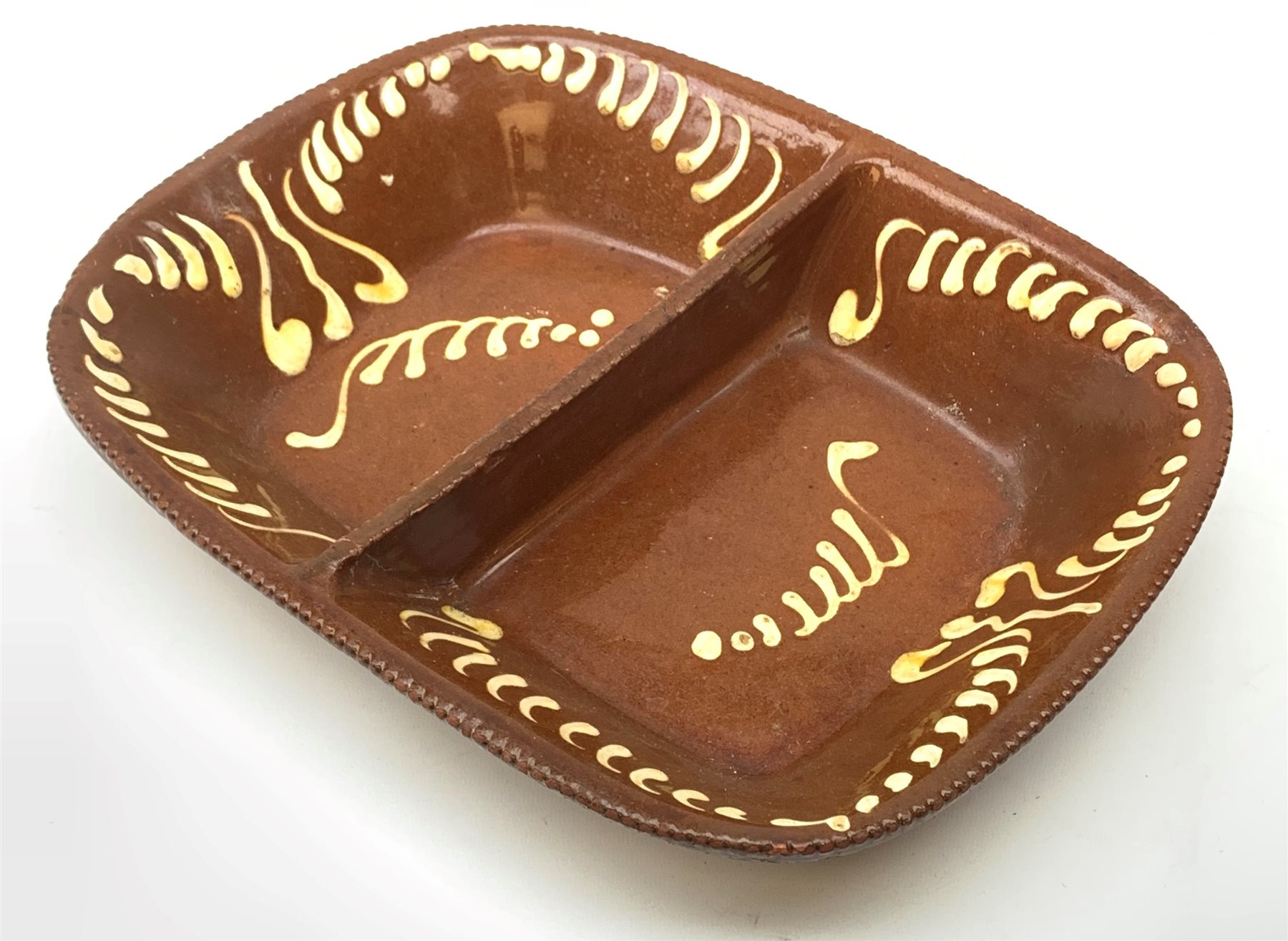 A Victorian terracotta two-division dish of rounded oblong form with ...