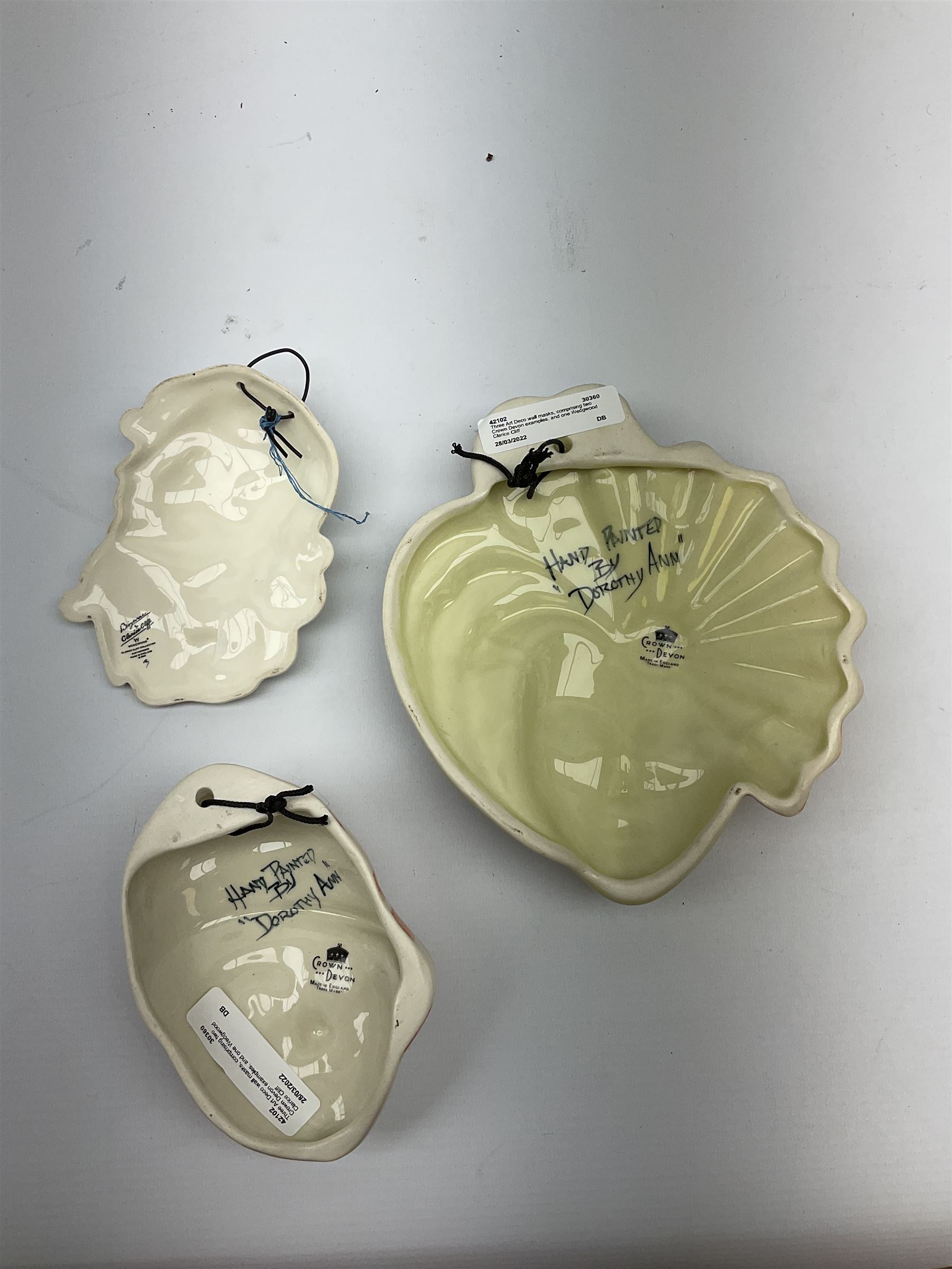 Three Art Deco wall masks, comprising two Crown Devon masks, inscribed ...